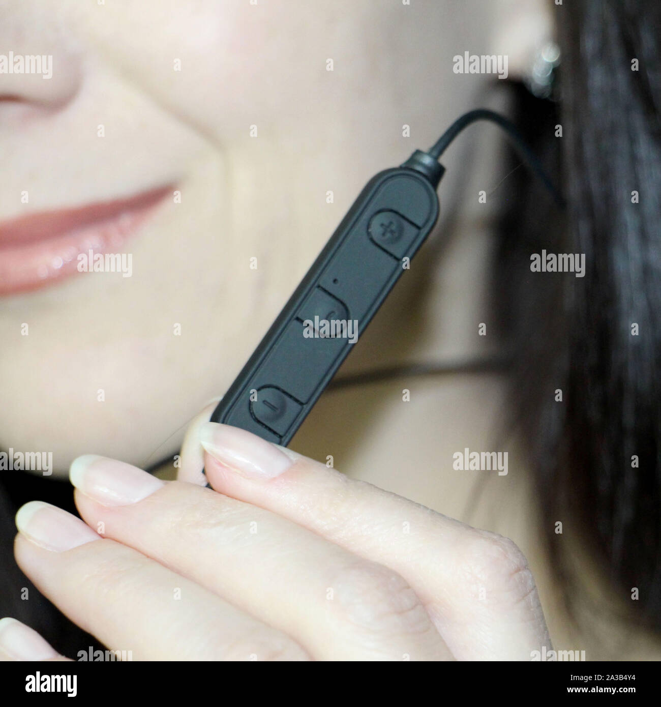 Musical headphones in the ear of a young woman. Girls ear with earphone ...