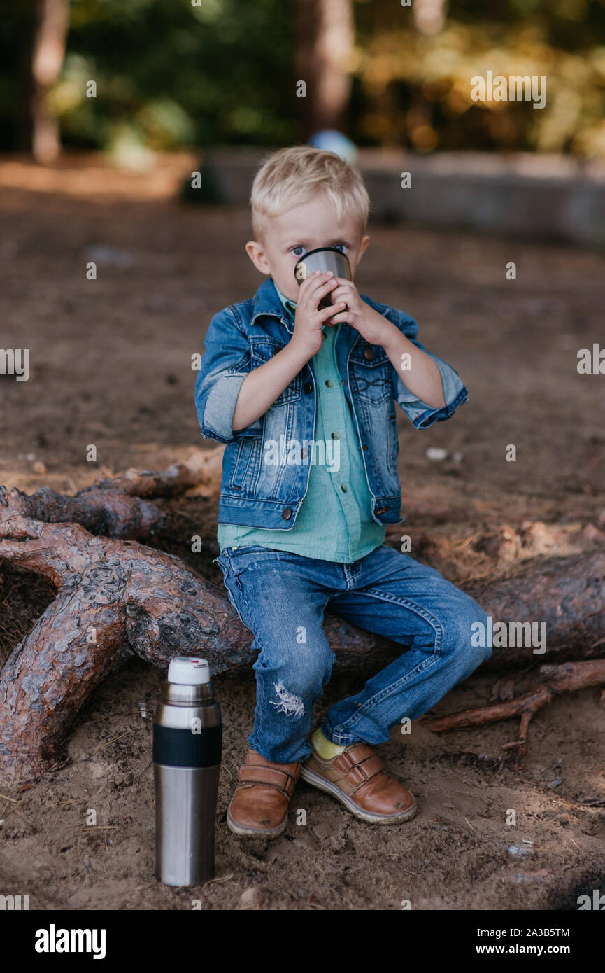 little boy holding a cup of tea outdoors. child drinks tea Stock Photo ...
