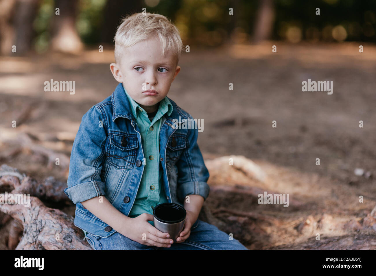 little boy holding a cup of tea outdoors. child drinks tea Stock Photo ...