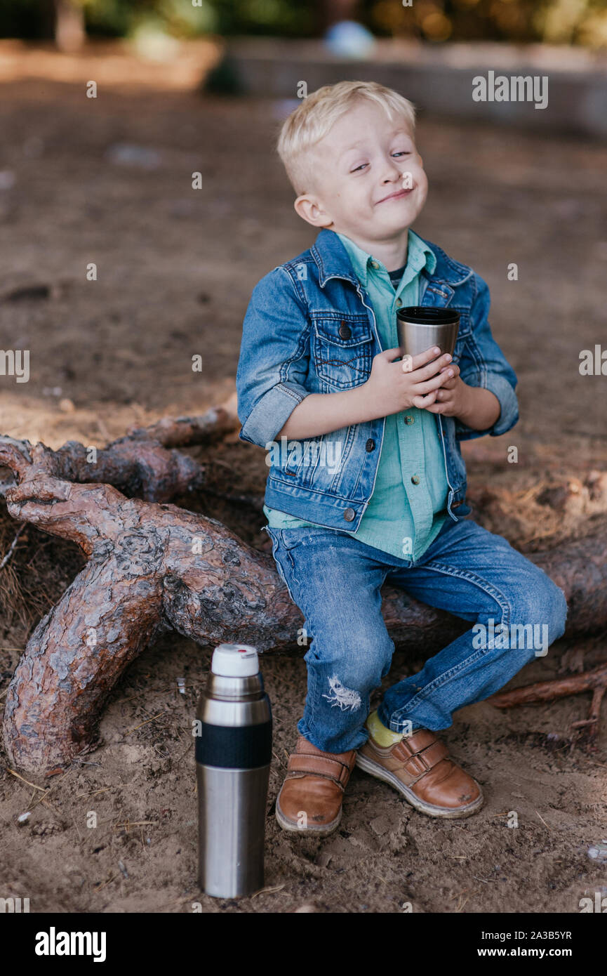 little boy holding a cup of tea outdoors. child drinks tea Stock Photo ...