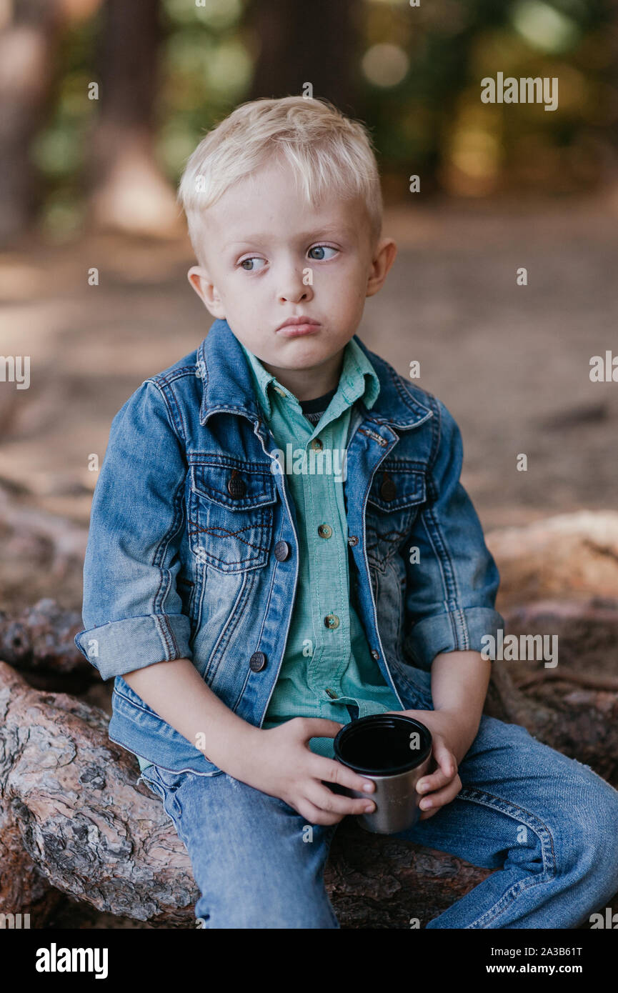 little boy holding a cup of tea outdoors. child drinks tea Stock Photo ...
