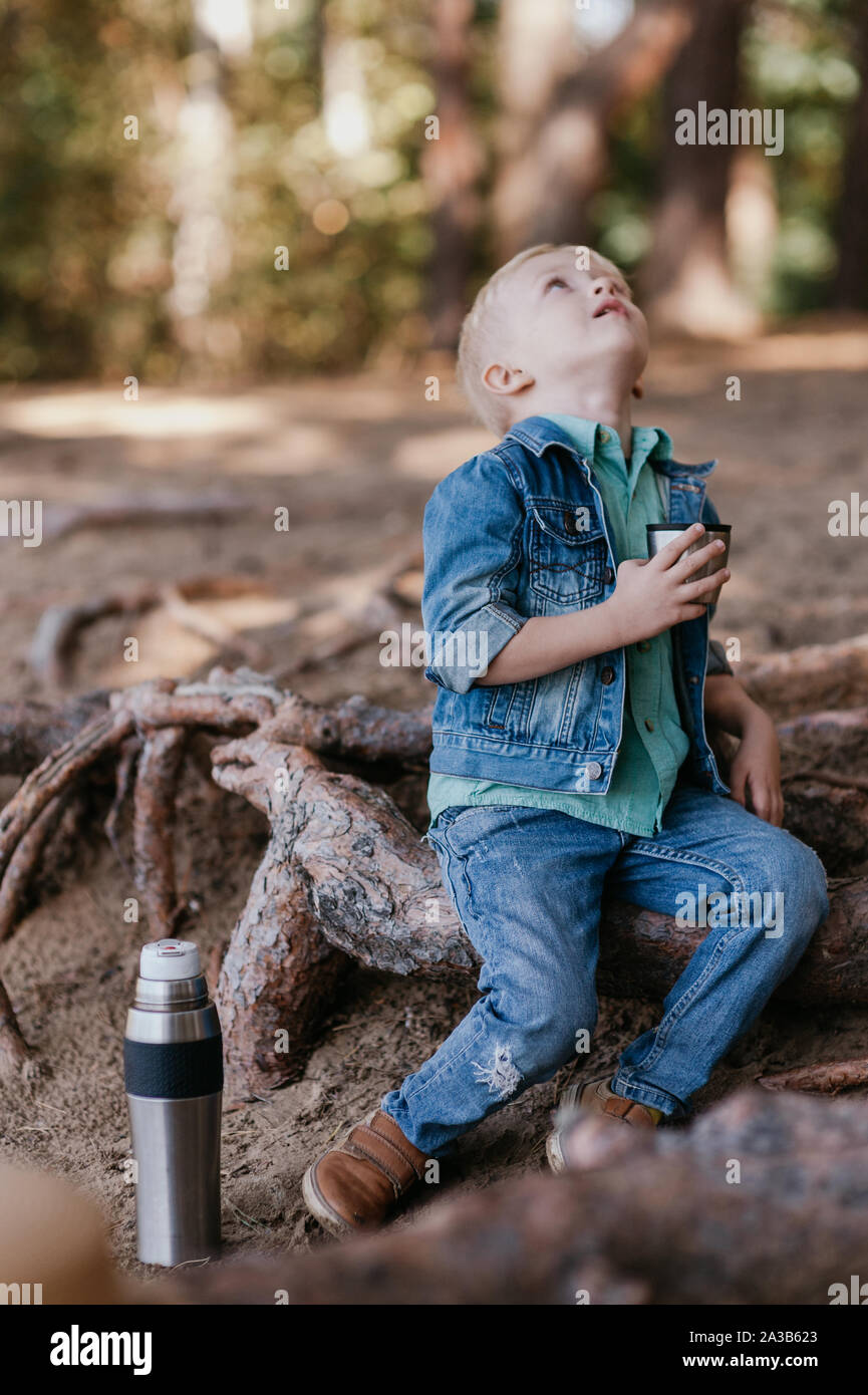 little boy holding a cup of tea outdoors. child drinks tea Stock Photo ...