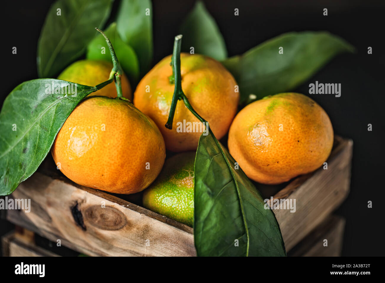 Tangerines with leaves on an old fashioned country table. Selective ...