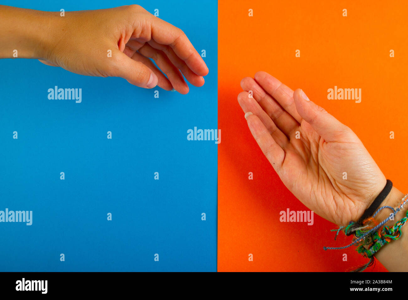 Helping hand concept. Two hands on colorful background Stock Photo - Alamy