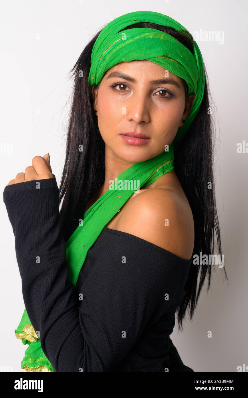 Face of young beautiful Persian woman with head scarf looking at camera ...