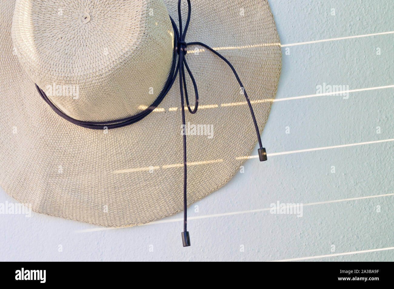 Straw hat hanging on wall Stock Photo - Alamy