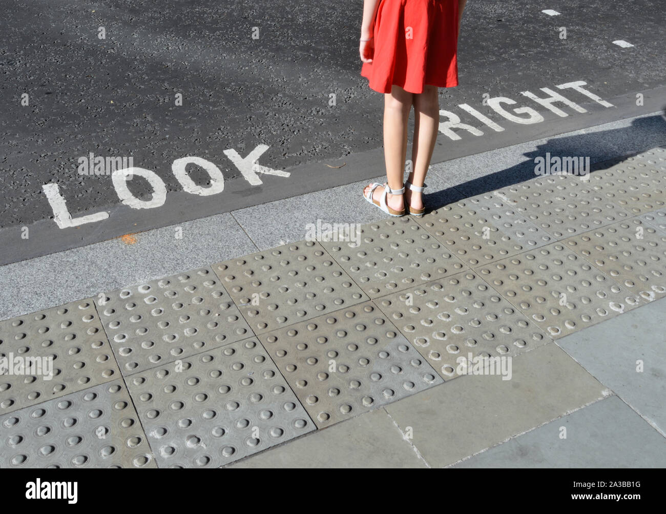 Pedestrian standing next to typical road crossing sign in London Stock ...