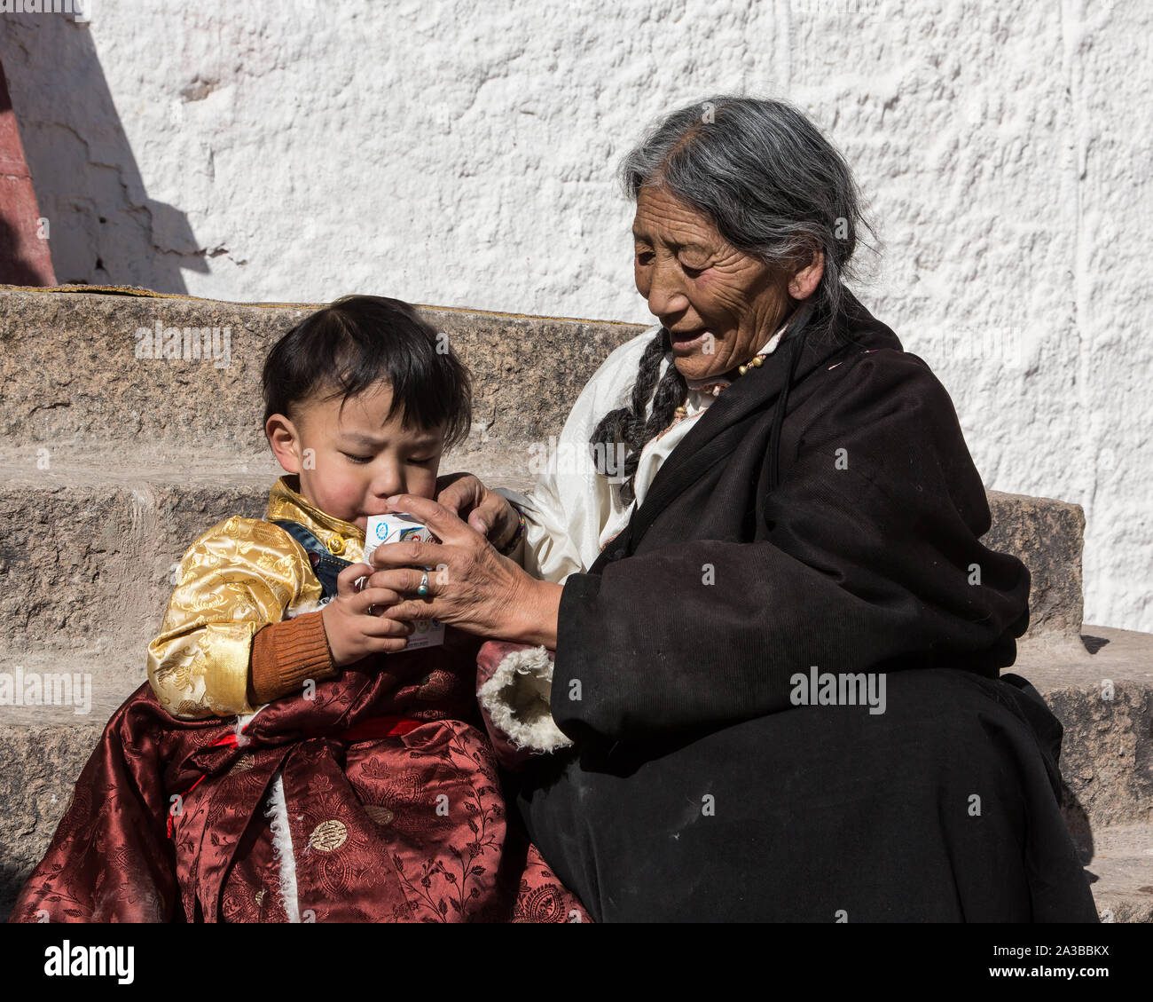 A Khamba grandmother from the Kham region of Tibet helps her grandson ...