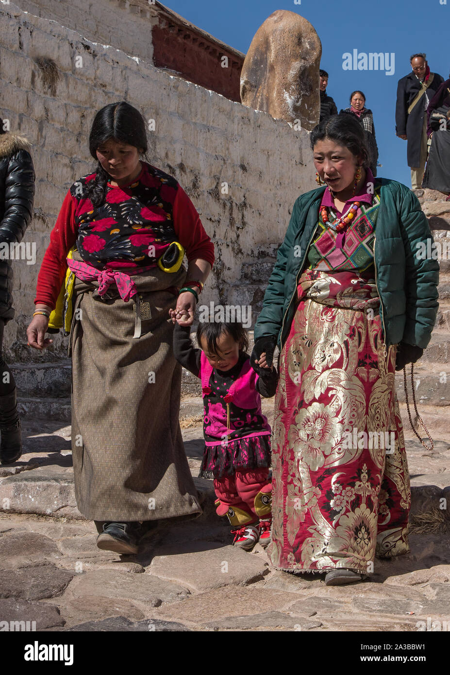 Tibetan women in traditional dress with a child making a pilgrimage to ...