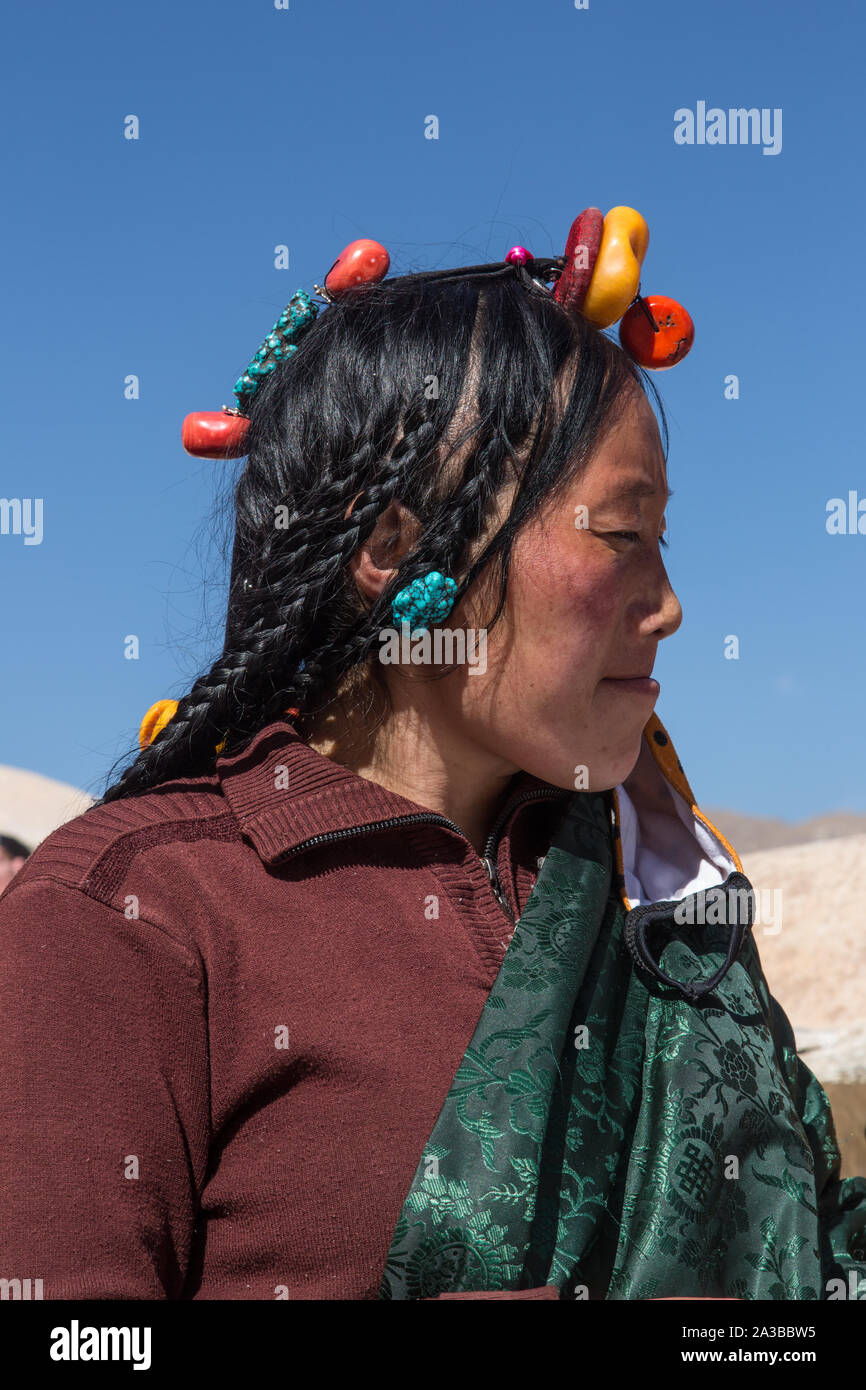 A Khamba Tibetan woman from the Kham region of Tibet with her hair in ...