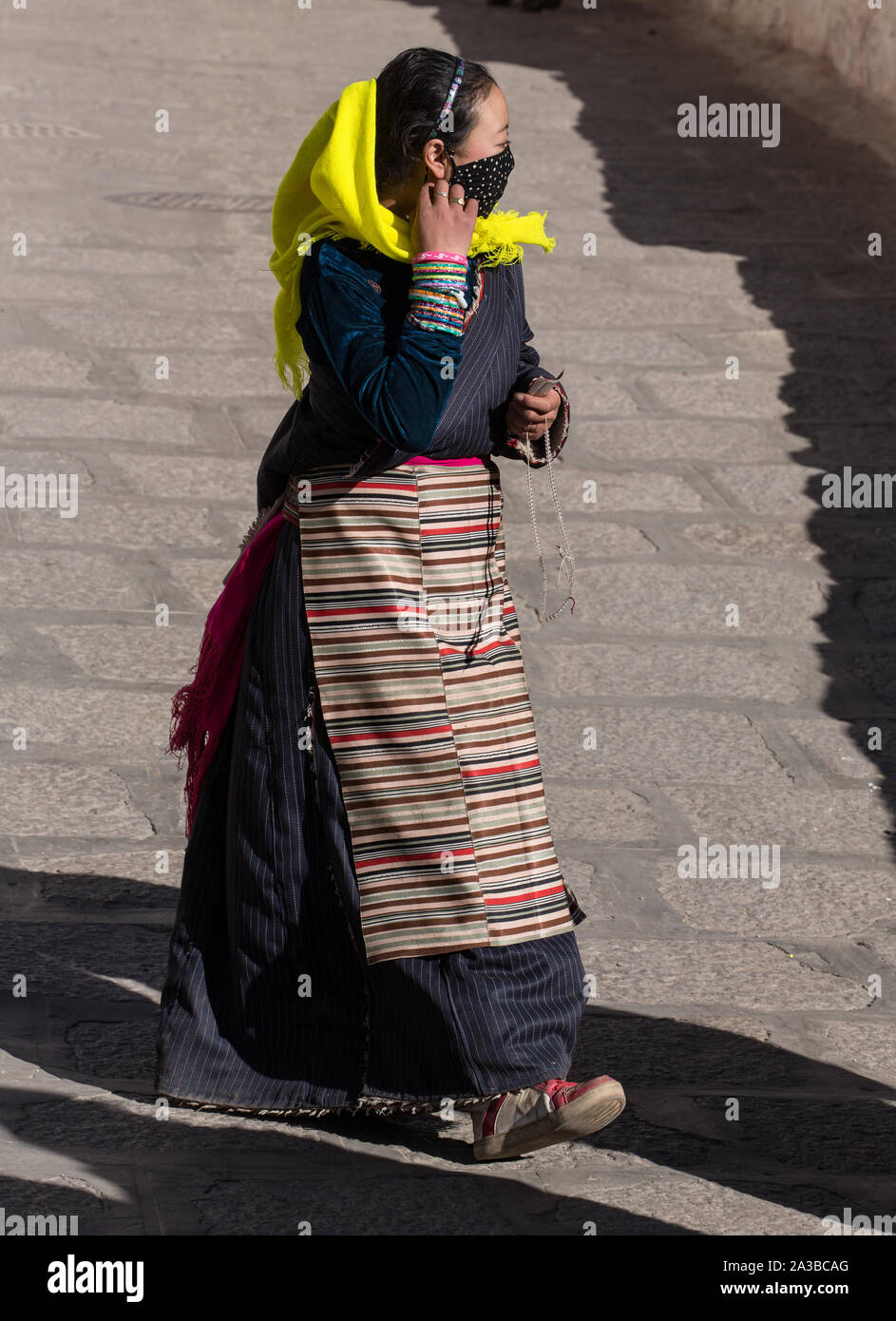 A Tibetan woman pilgrim in traditional dress, including her colorful ...