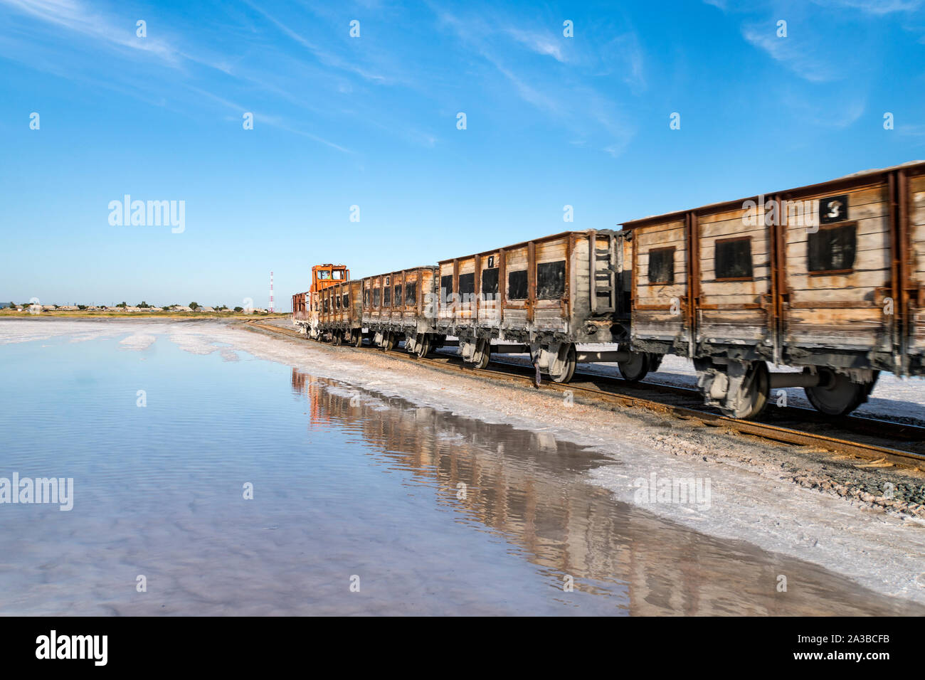 Old train rides on the railway laid in the water through the salt lake ...