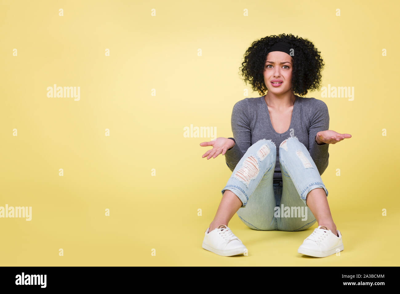 Young woman with questioning look isolated on yellow background Stock ...