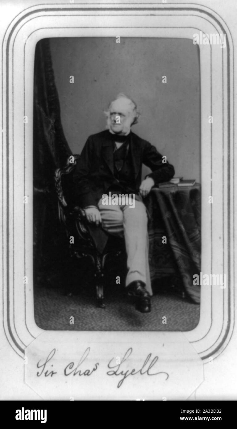 Sir Charles Lyell, full-length portrait, seated at small table, facing ...