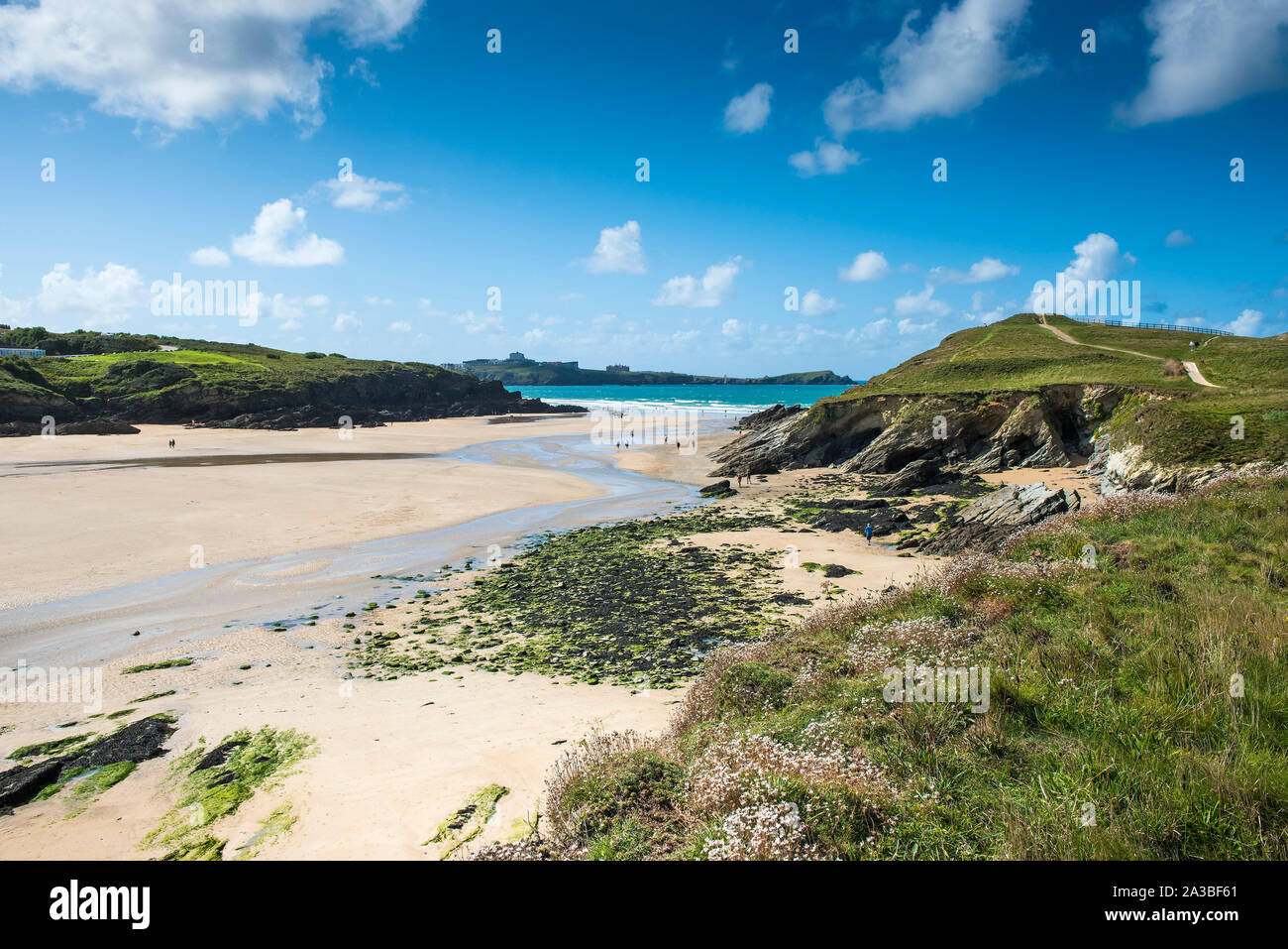 A spring tide exposes the rocks at Porth Beach in Newquay in Cornwall ...