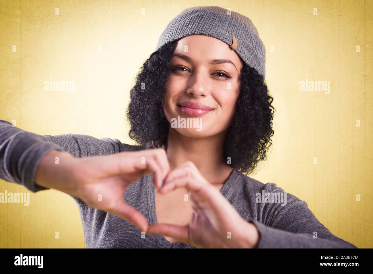 Beautiful woman smiling and showing a heart Stock Photo - Alamy