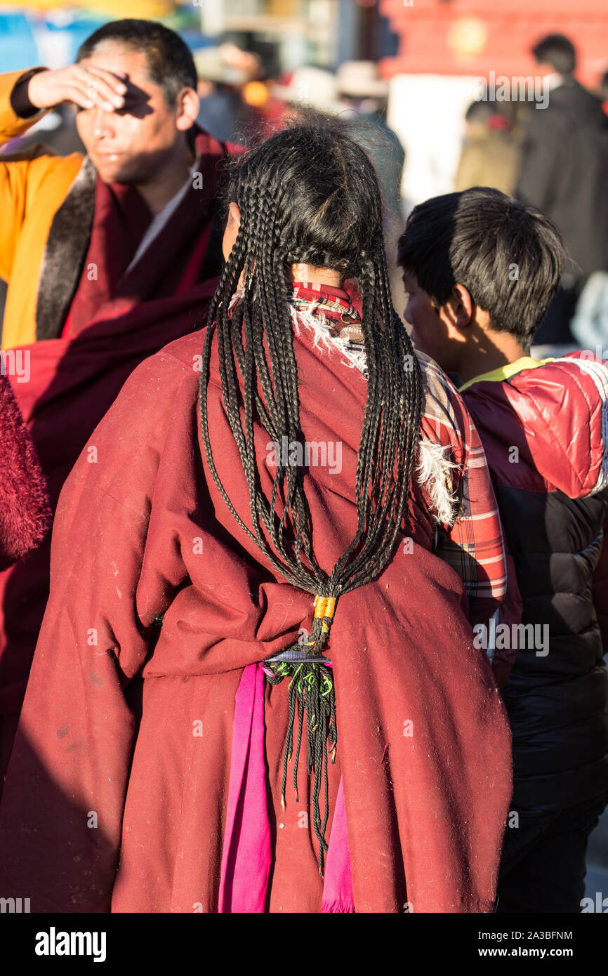 An older Tibetan woman pilgrim with her family at the Jokhang Temple ...