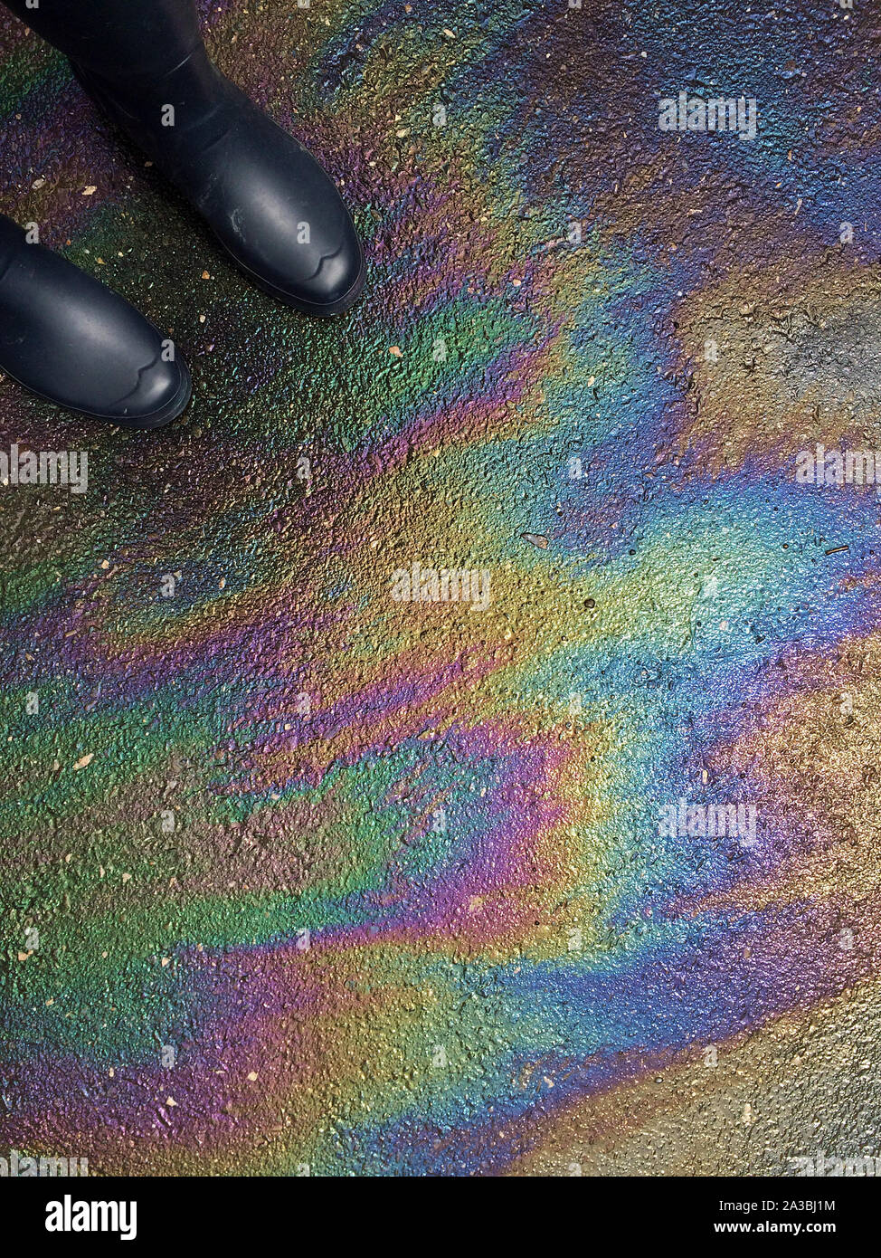 Rain boots on oil spill Stock Photo - Alamy