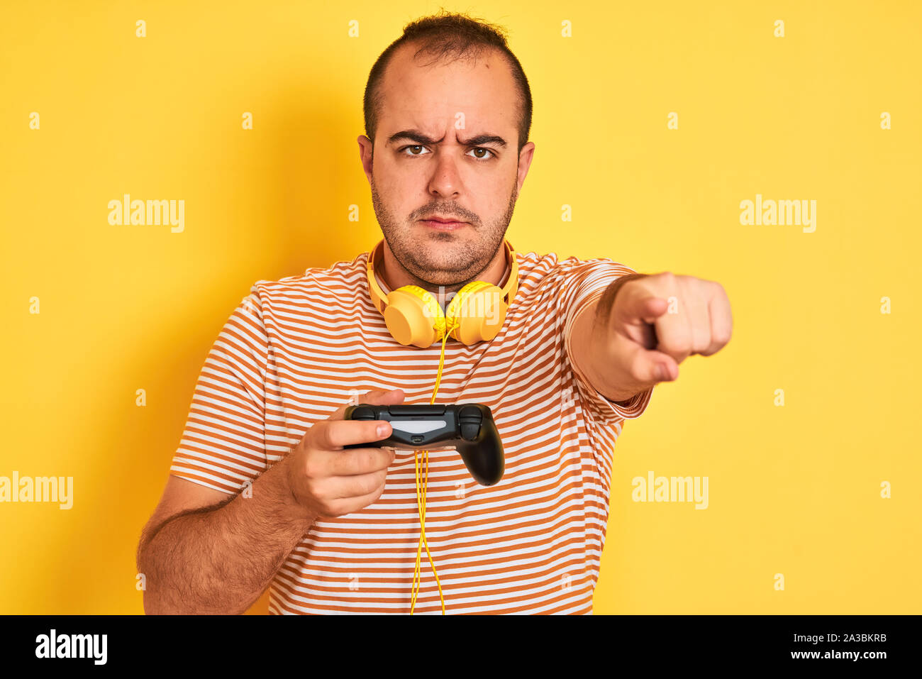 Young gamer man playing video game using headphones over isolated ...