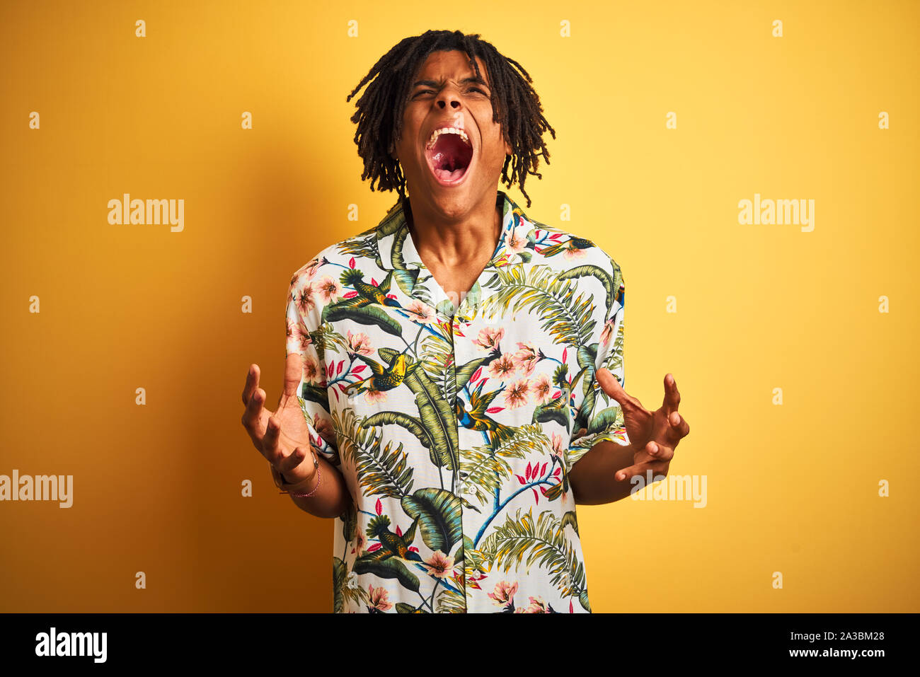 Afro man with dreadlocks on vacation wearing summer shirt over isolated ...