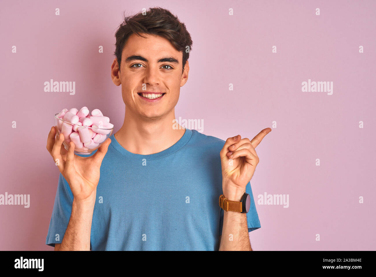 Teenager boy holding a bunch of delicious fluffy marshmallow over ...