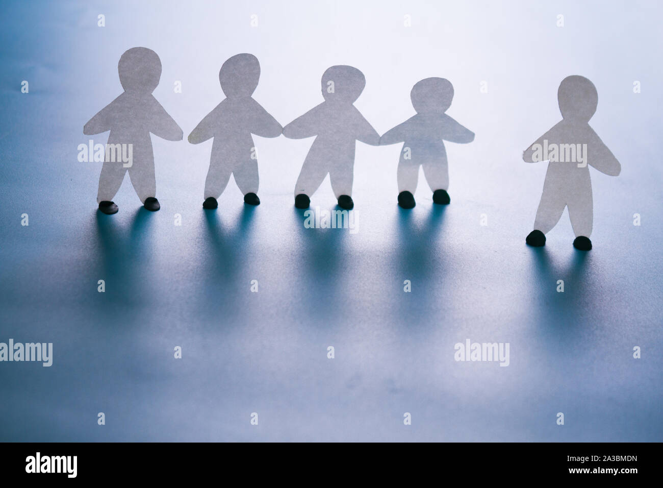 Paper people on blue background with copy space Stock Photo - Alamy