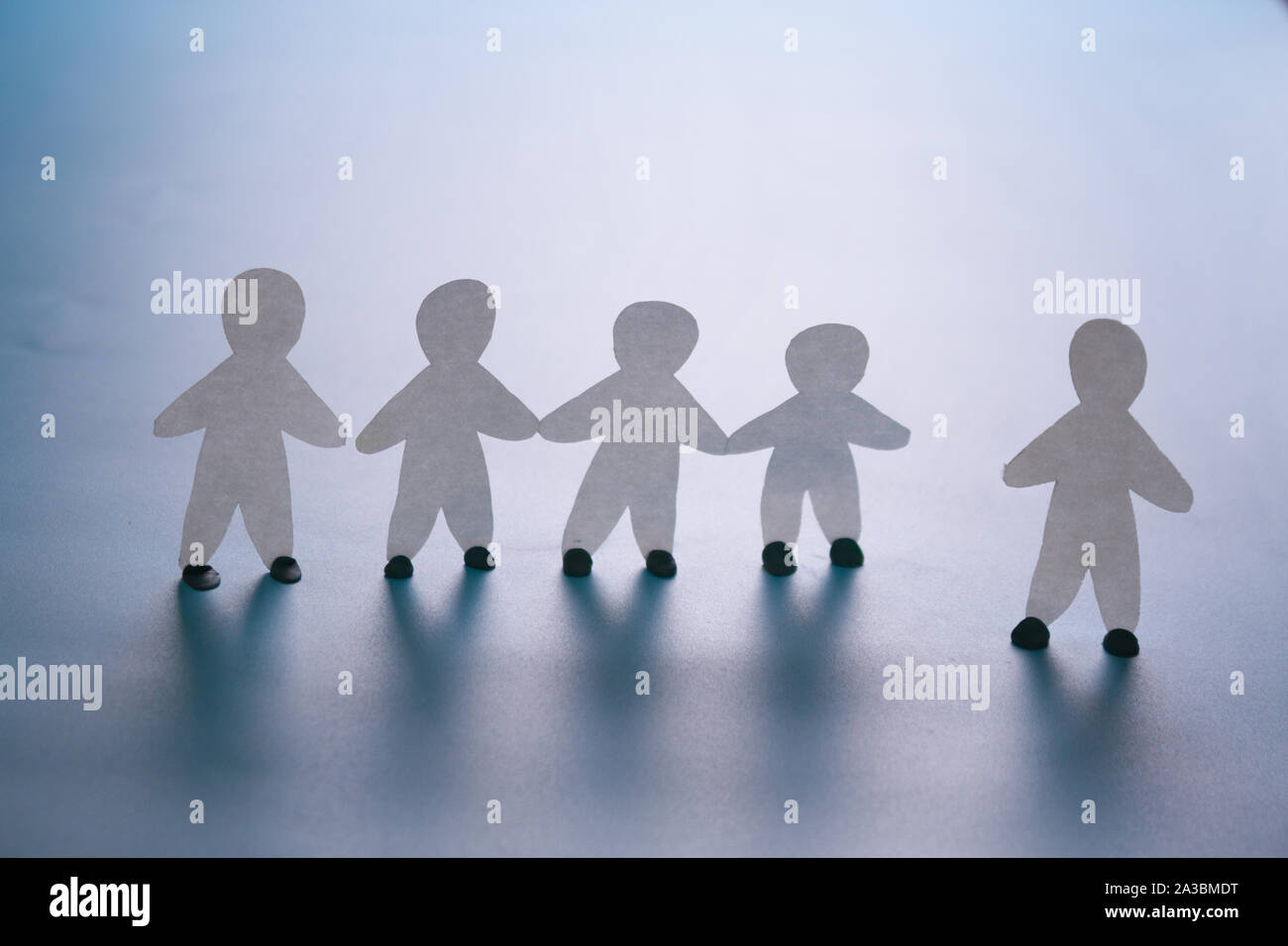 Paper people on blue background with copy space Stock Photo - Alamy