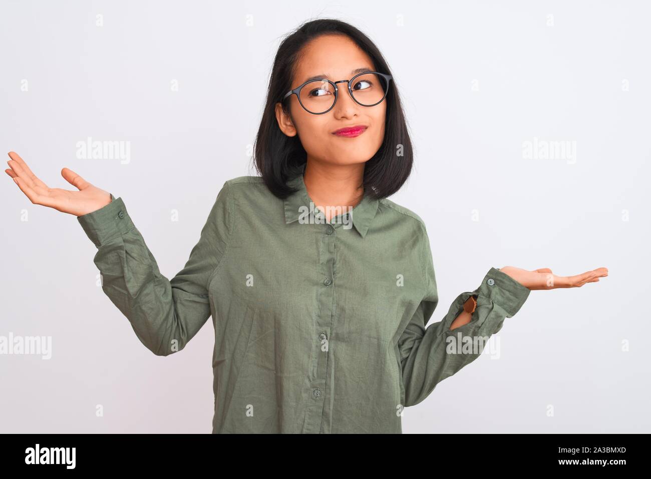 Young chinese woman wearing green shirt and glasses over isolated white ...