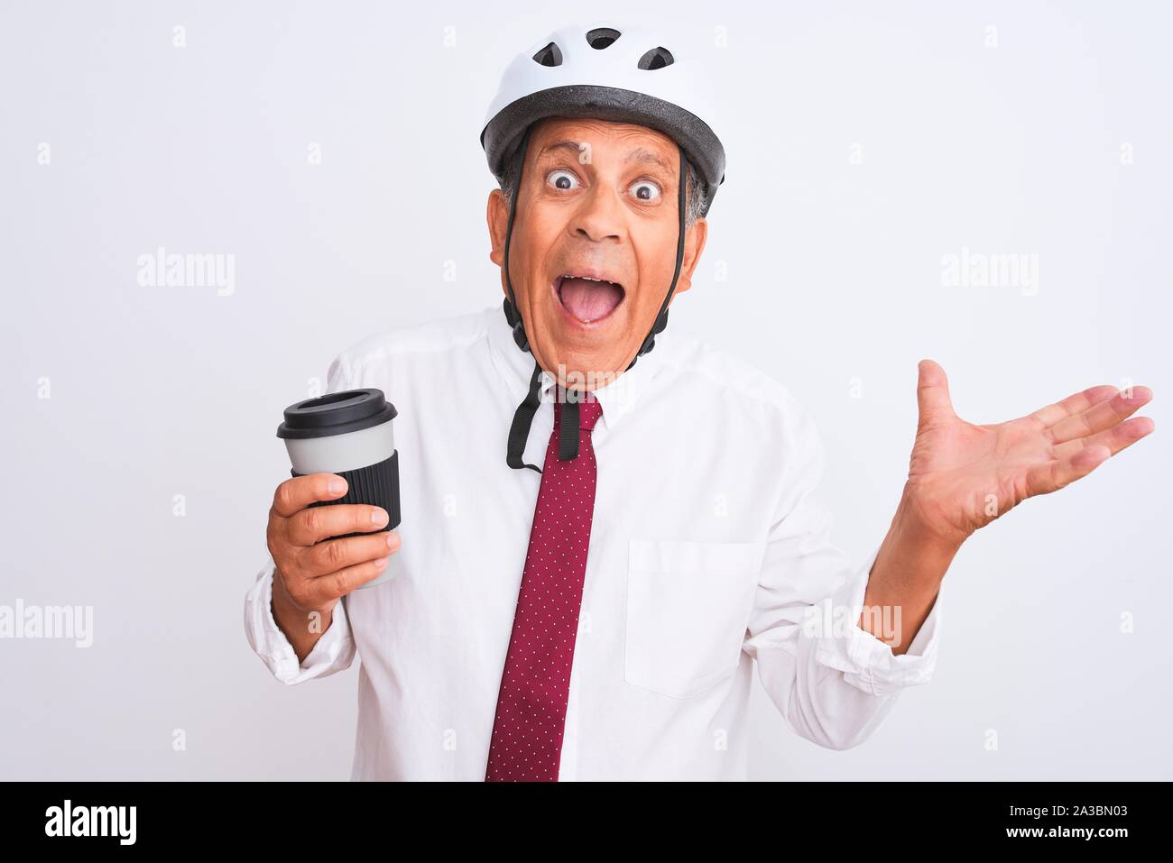 Senior businessman wearing bike helmet drinking coffee over isolated white background very happy ...