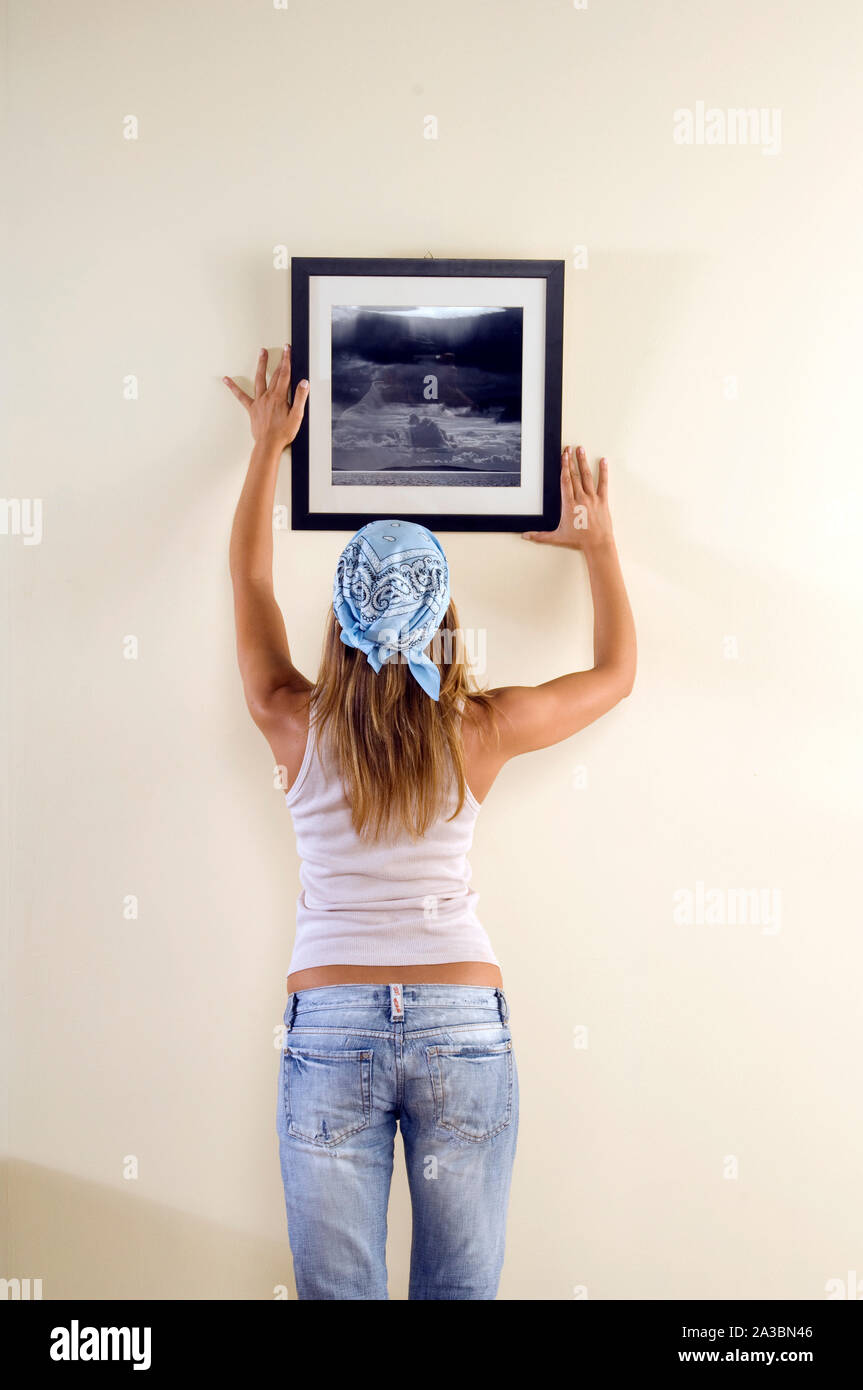 woman hanging a picture Stock Photo - Alamy