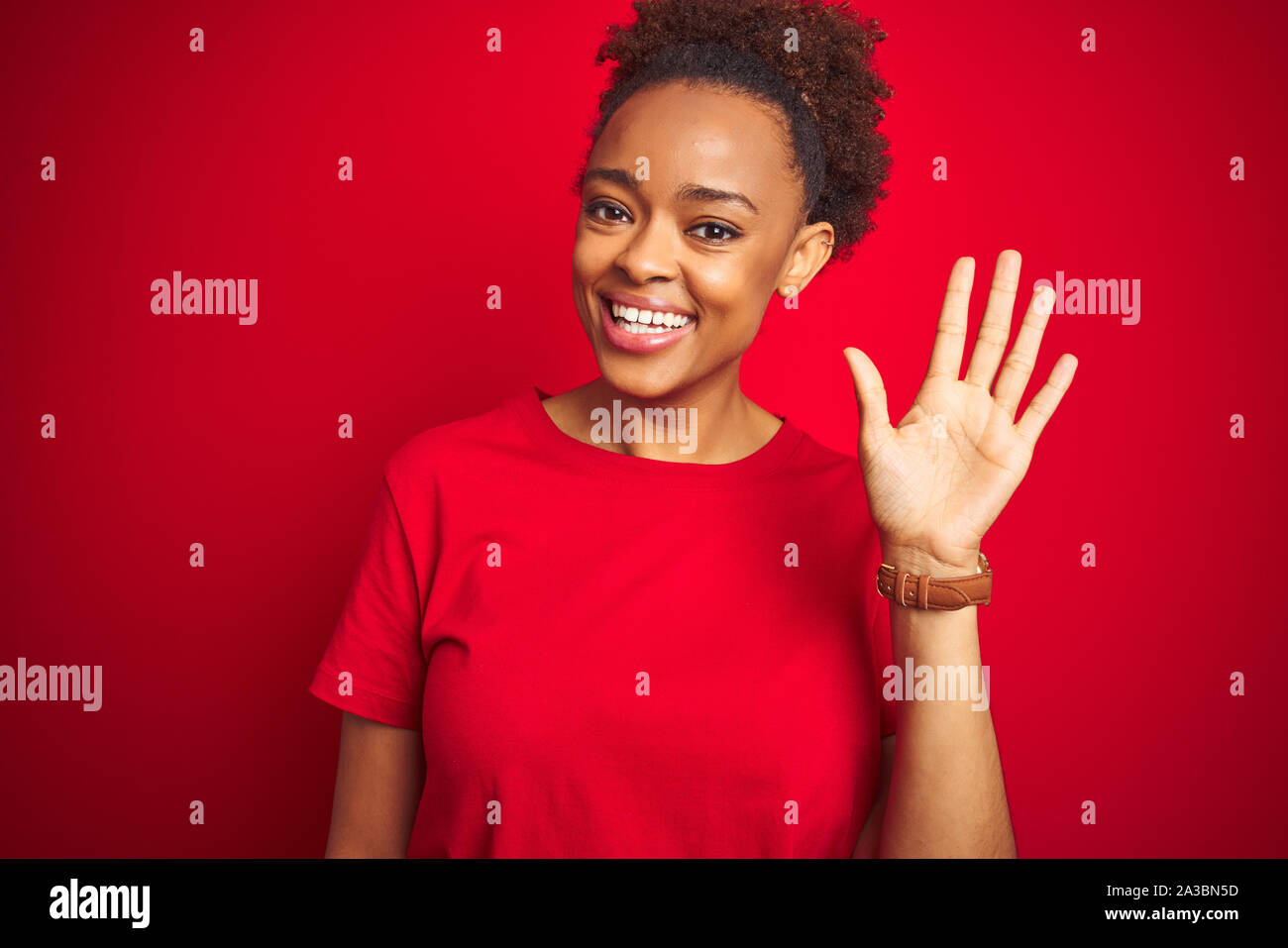 Young beautiful african american woman with afro hair over isolated red ...