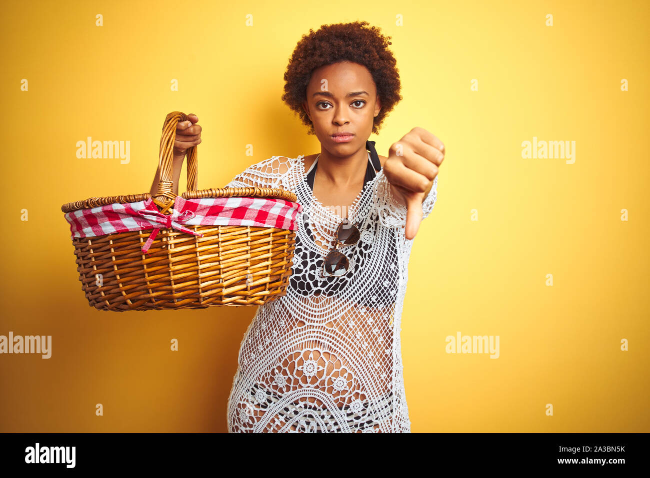Young african american woman holding picnic basket on vacation over ...