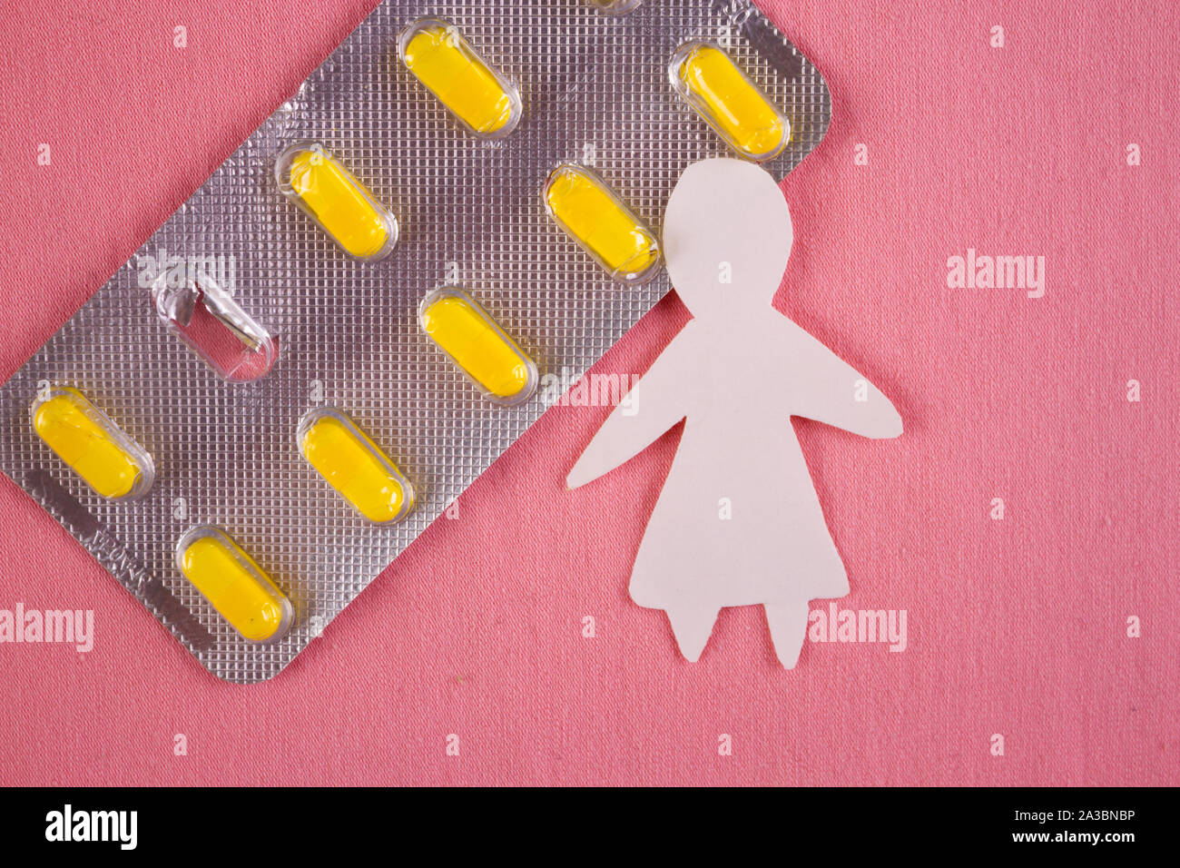 Contraceptive pill concept. Pills and paper woman on pink background ...