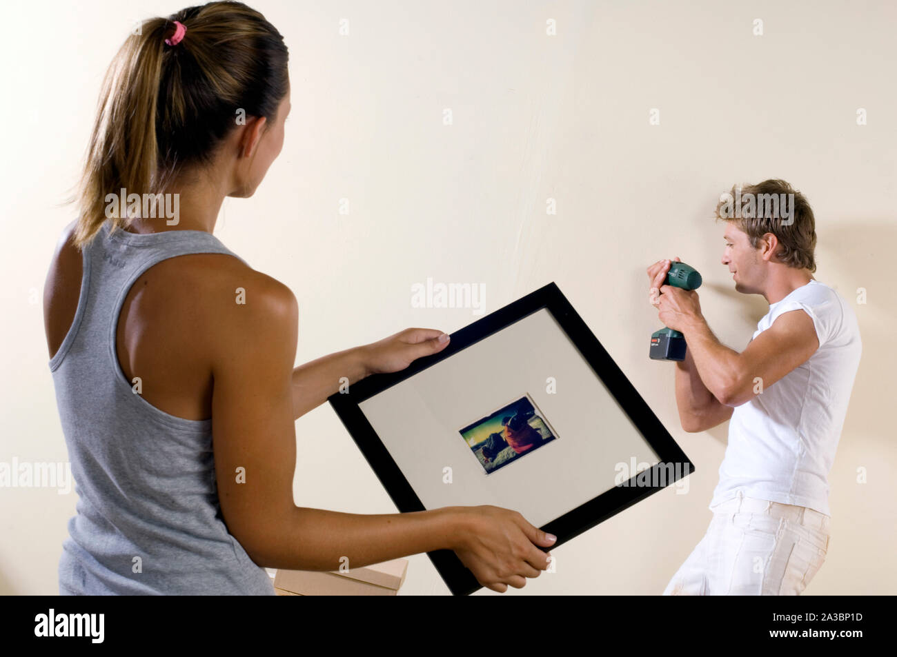 Woman hanging pictures at home hi-res stock photography and images - Alamy