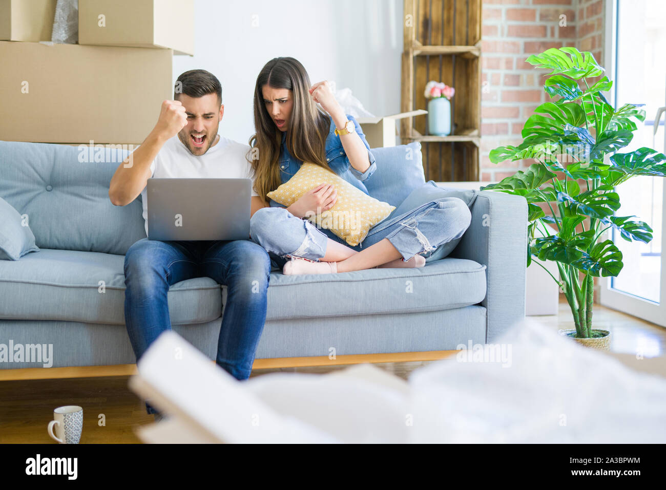Young beautiful couple relaxing sitting on the sofa of new house using ...