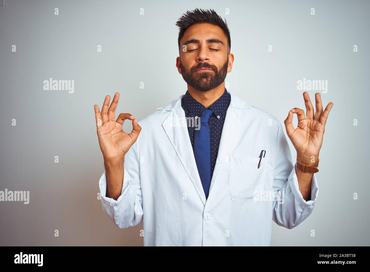 Young indian doctor man standing over isolated white background relax ...