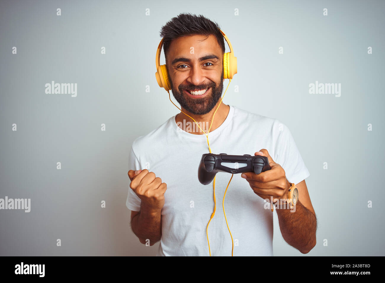 Arab indian gamer man playing video game using headphones over isolated ...