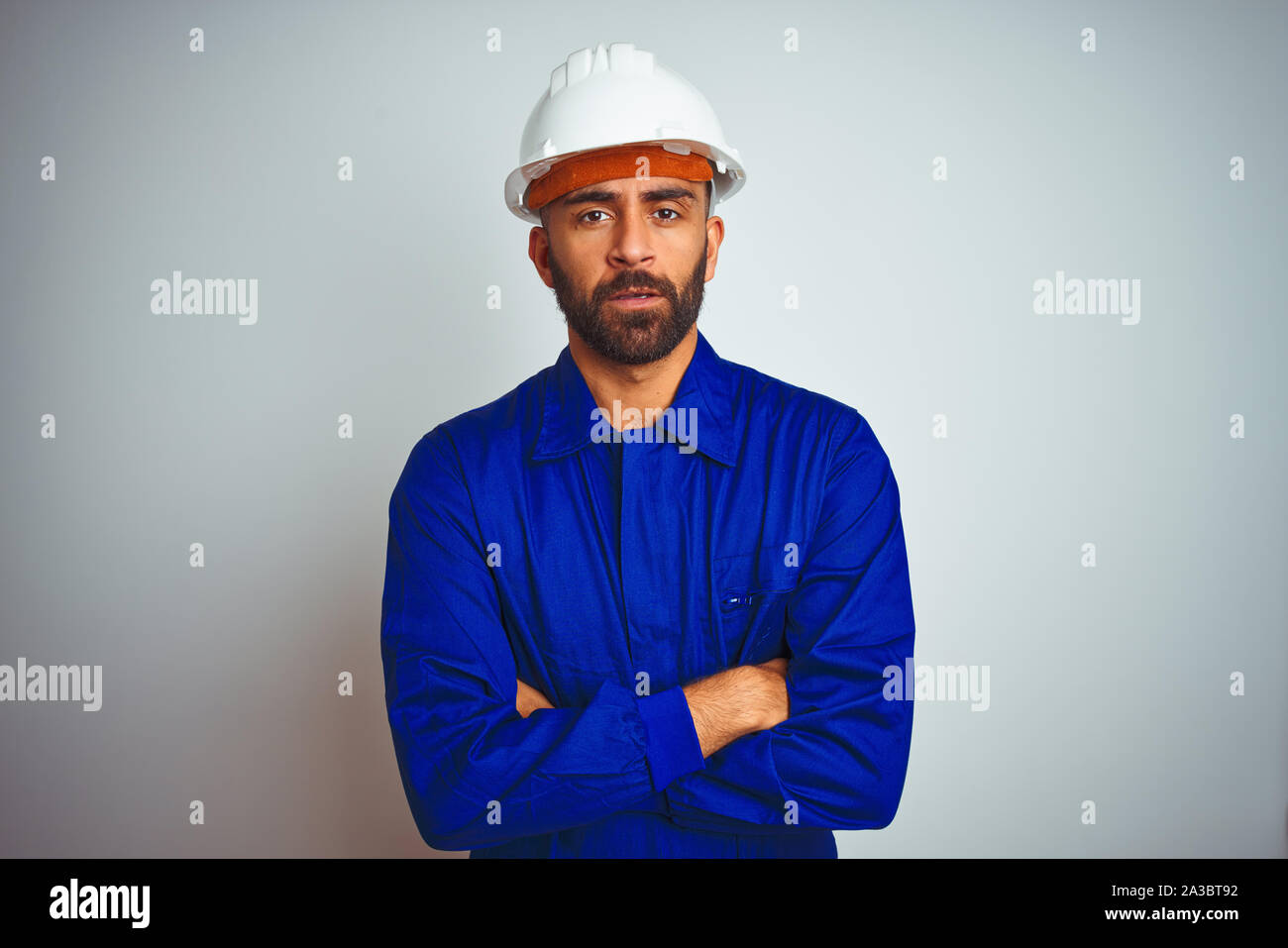 Handsome indian worker man wearing uniform and helmet over isolated ...