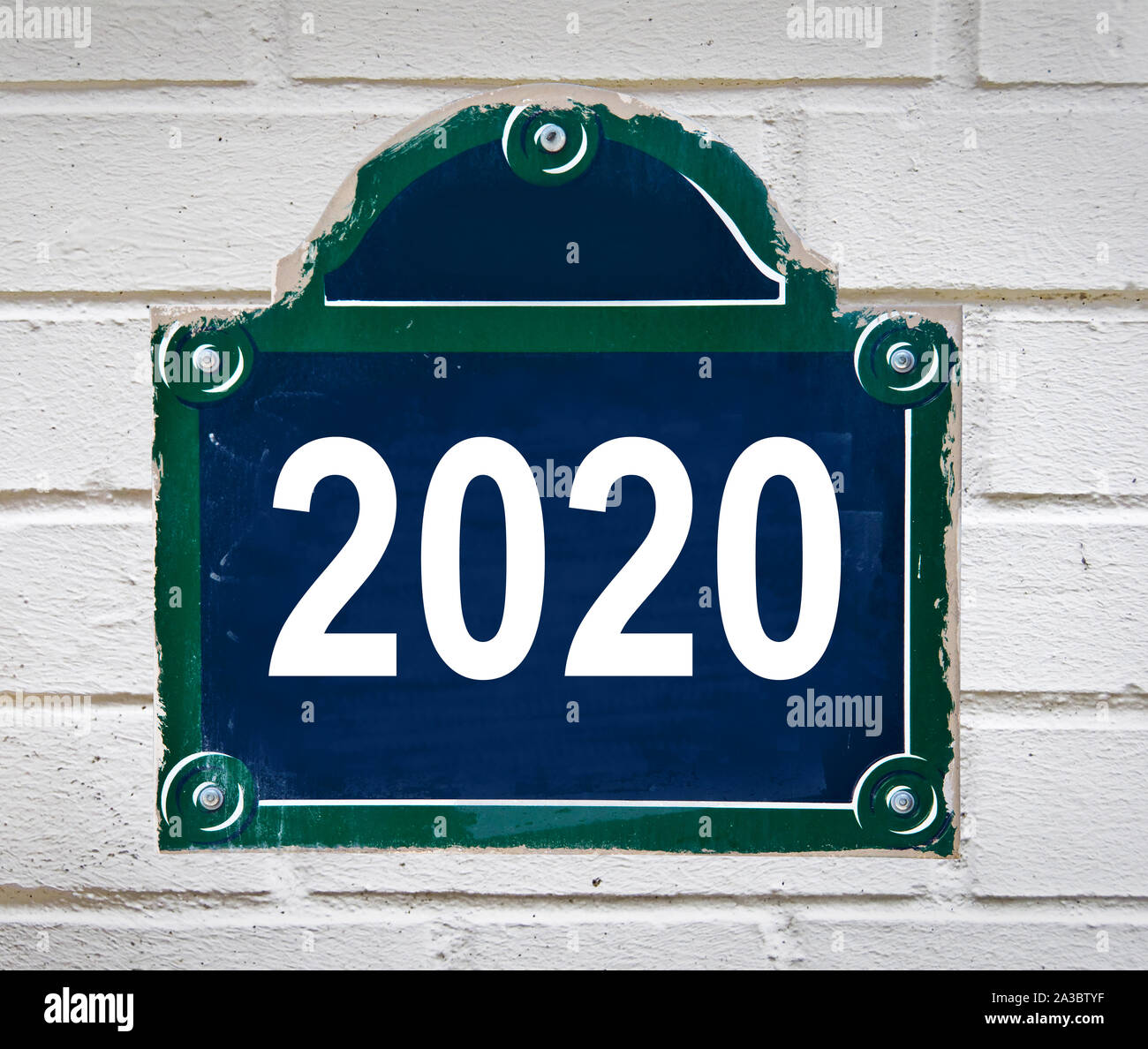 2020 written on a Paris street plate on white brick wall background ...
