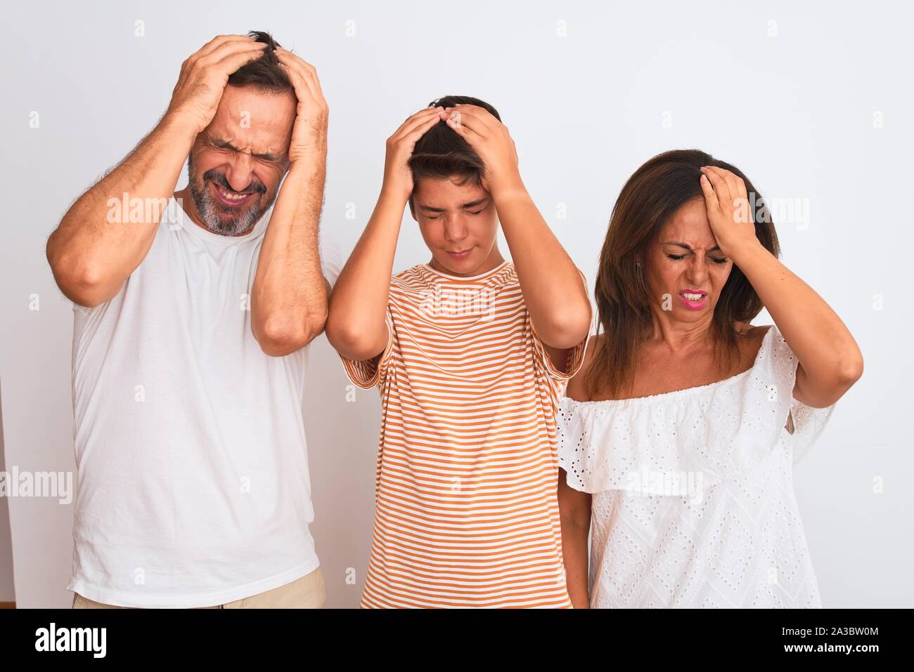 Family of three, mother, father and son standing over white isolated ...