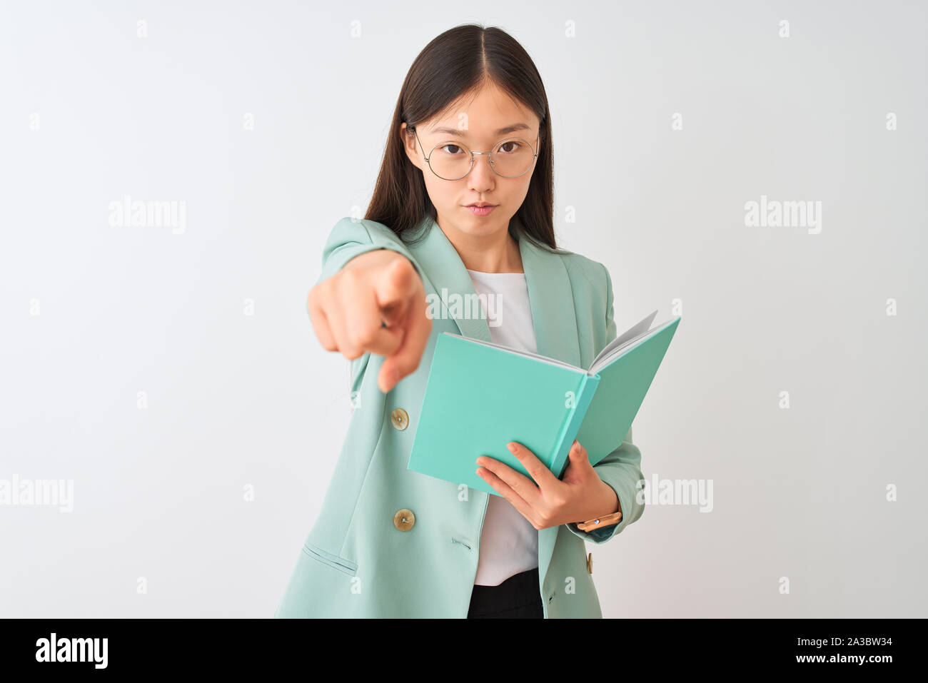 Young chinese student woman wearing glasses reading book over isolated ...