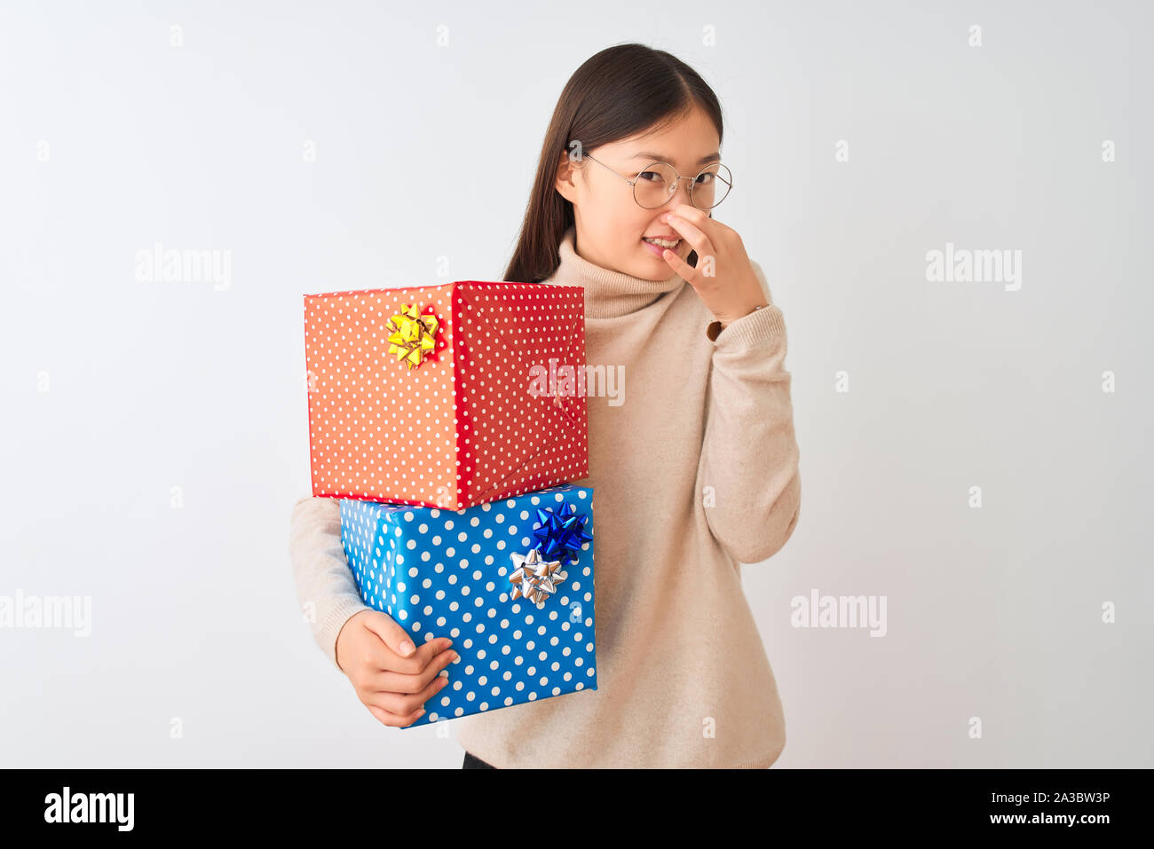 Young chinese woman holding birthday gifts over isolated white ...