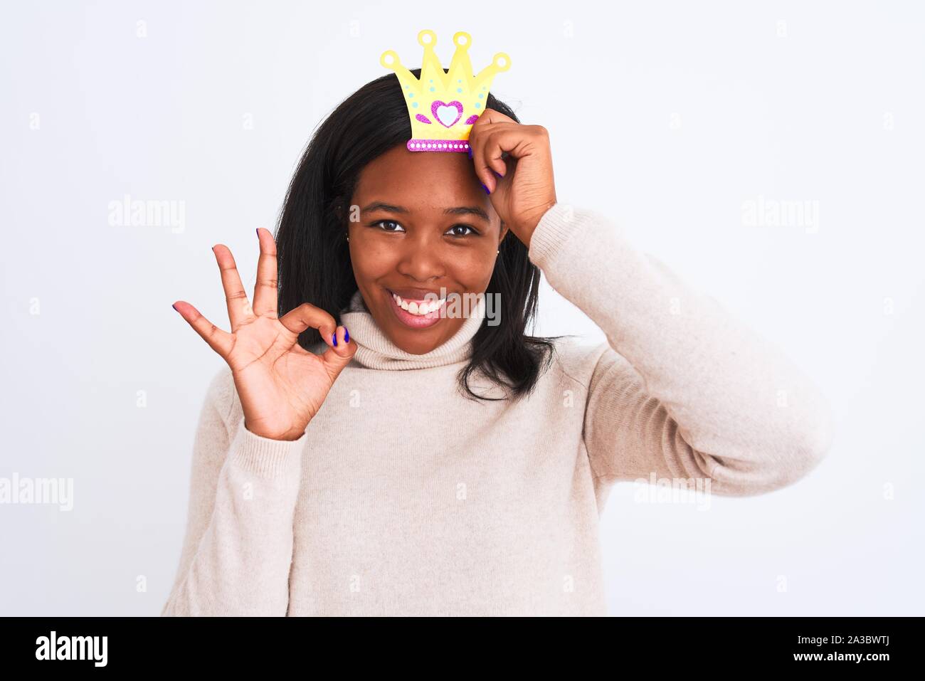 Young african american woman wearing pretend queen crown over isolated ...