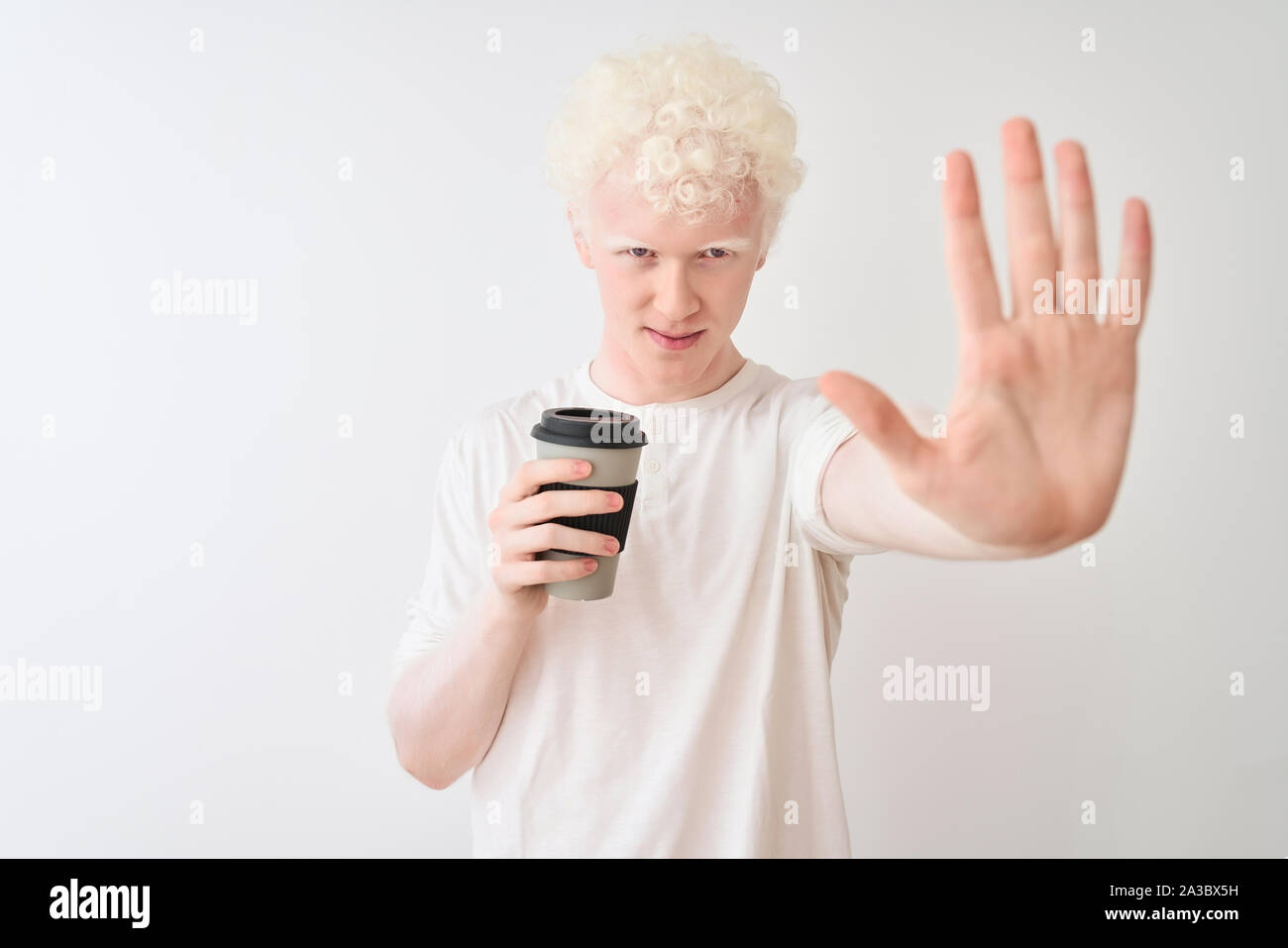 Young albino blond man drinking coffee standing over isolated white ...