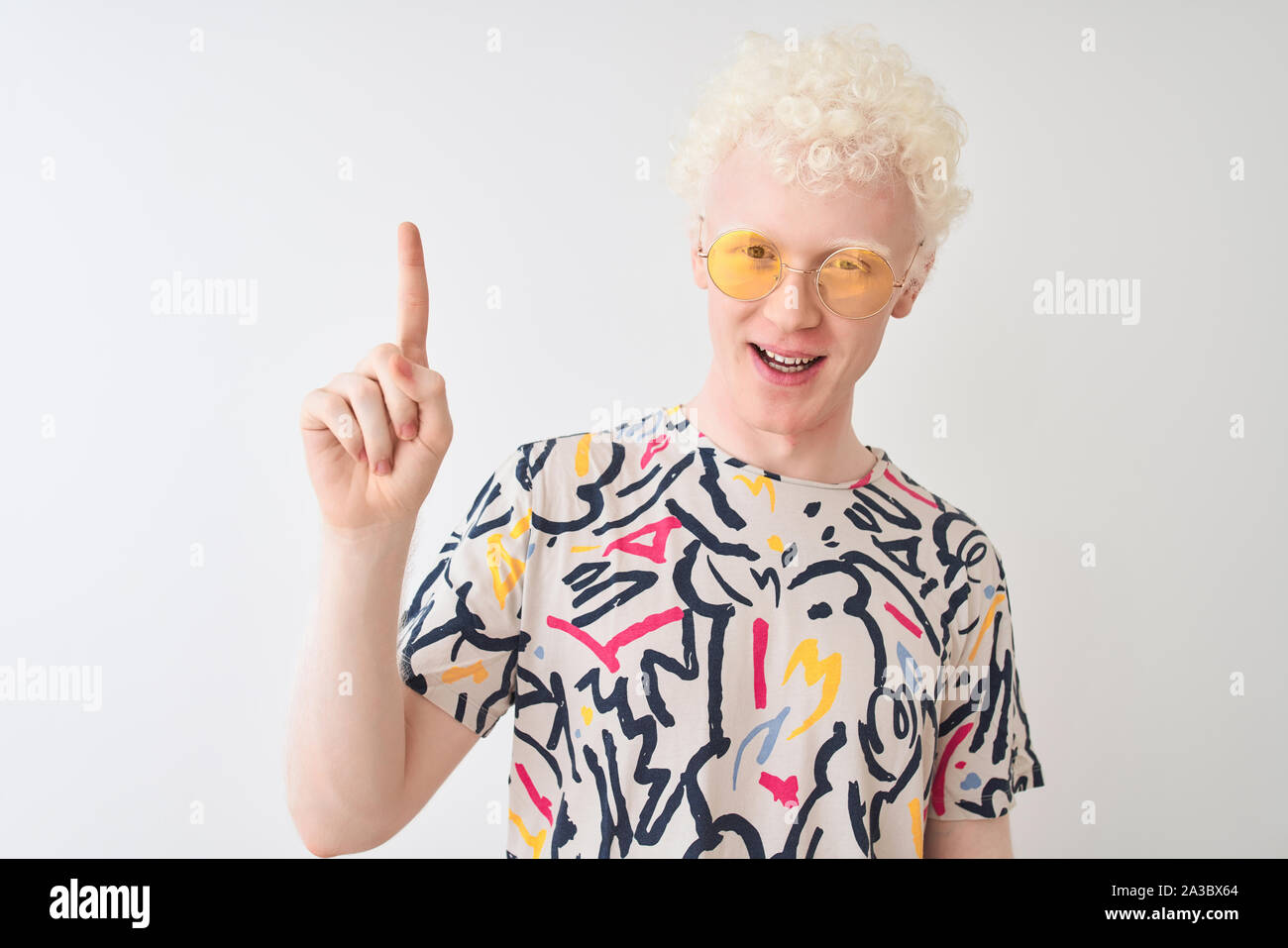 Young albino blond man wearing colorful t-shirt and sunglasses over ...