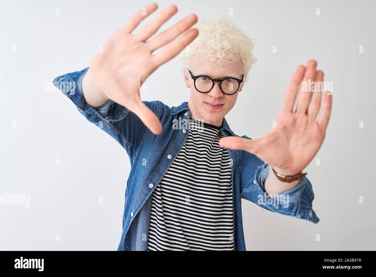 Young albino blond man wearing denim shirt and glasses over isolated ...