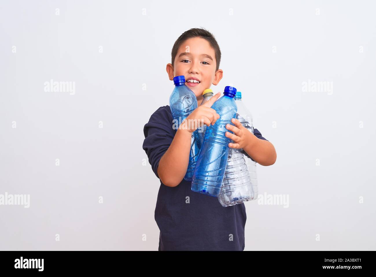 Beautiful kid boy recycling plastic bottles standing over isolated ...