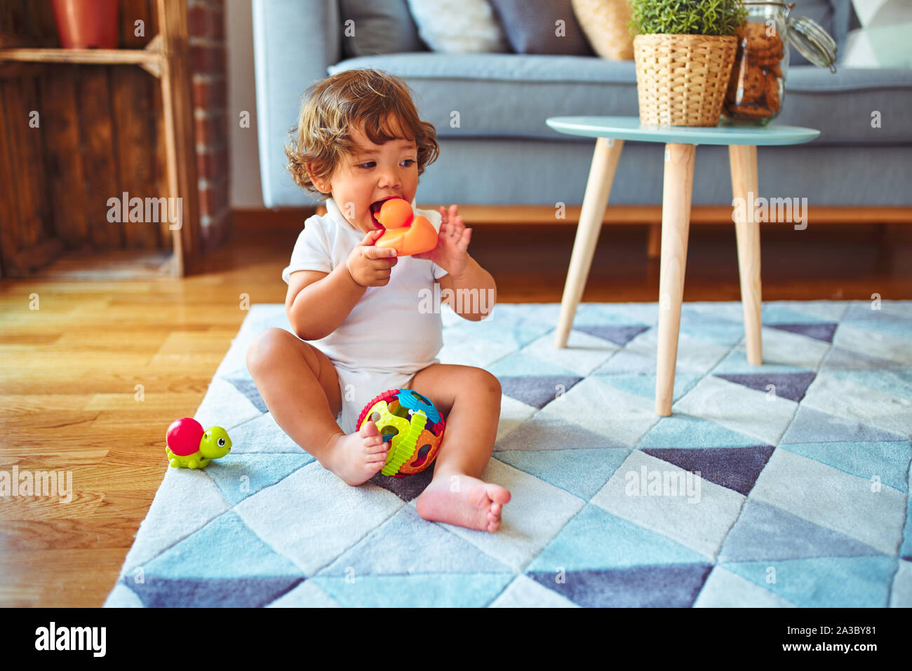 Beautiful toddler child girl playing with toys on the carpet Stock ...