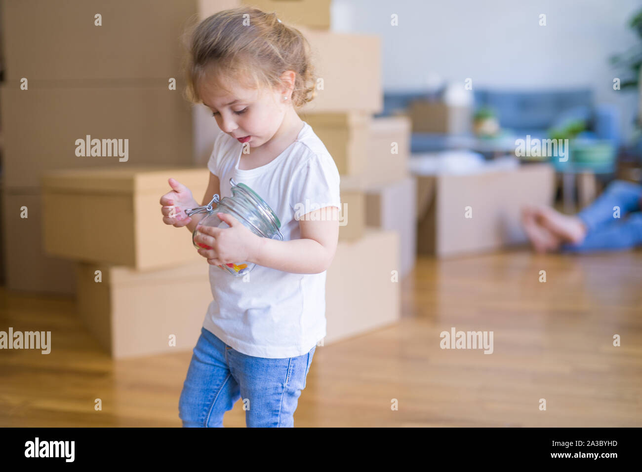 Beautiful toddler child girl holding jar of candies Stock Photo - Alamy