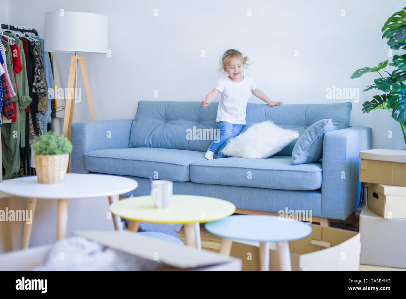Beautiful toddler child girl jumping on the sofa Stock Photo - Alamy